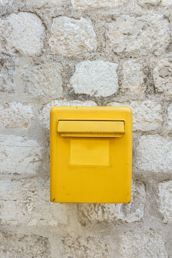 A Yellow Mailbox on a Light Stone Wall. Box for Letters and Postcards ...