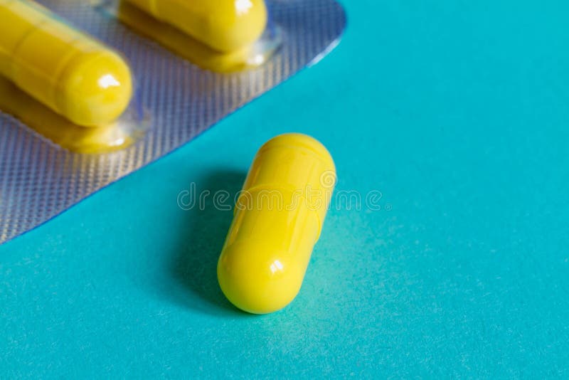 Yellow Medicine Capsule of the Drug on a Blue Background Stock Image ...