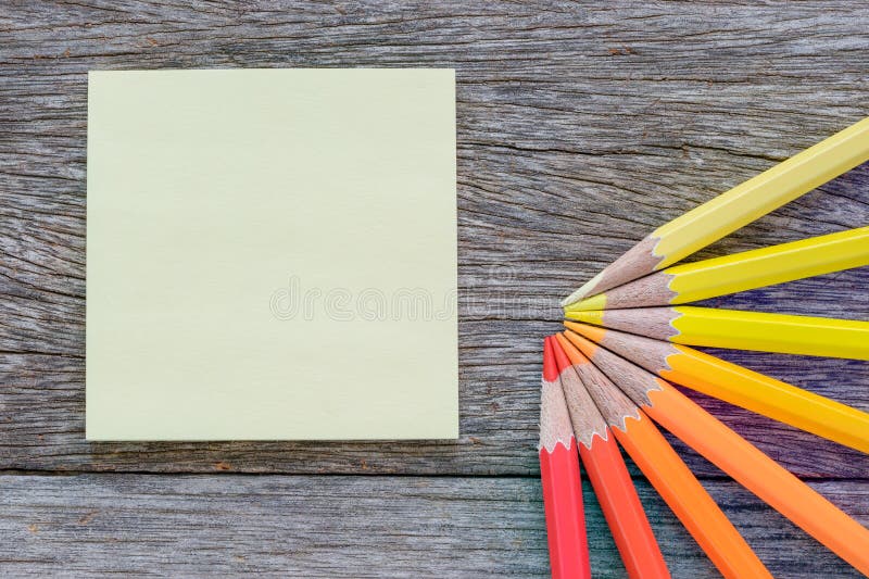 Yellow Meno Note and Colored Pencils on the Wooden Background. Stock ...