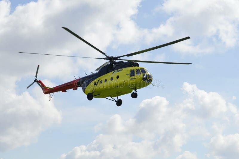 The Yellow MI-8 Helicopter Flies Against Clouds. Editorial Stock Photo ...