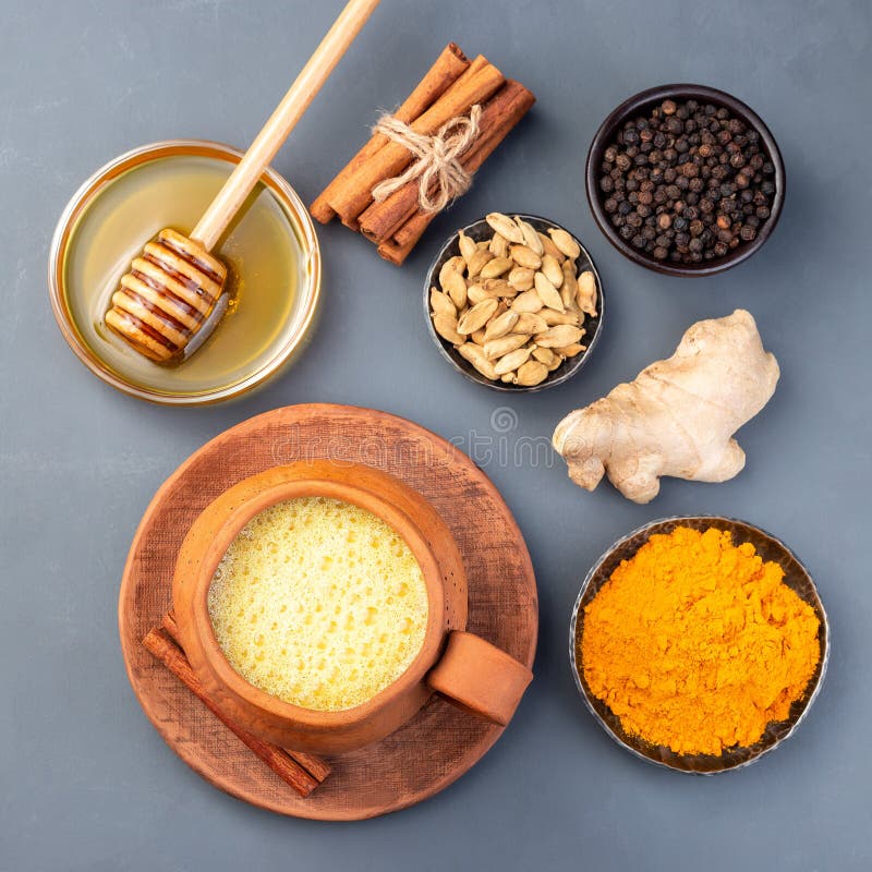 Yellow Moon Milk with Turmeric in a Clay Cup, Ingredients on Background ...