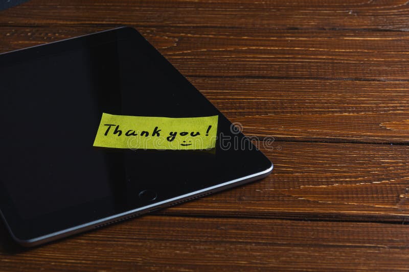 Yellow Note with the Word Thank You on the Tablet Screen on the Table ...