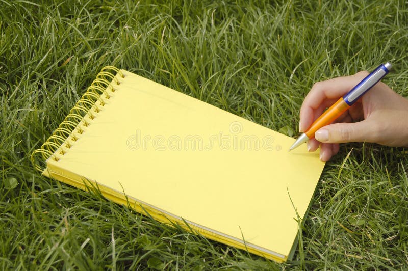 Yellow notebook in grass stock image. Image of billboard - 981597