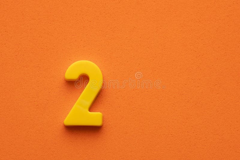 Yellow Number 2 - Plastic Piece on Orange Foamy Background Stock Photo ...