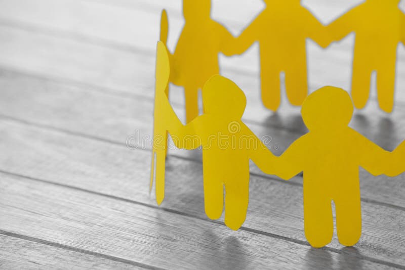 Yellow Paper Figures Holding Hands on Wooden Table Stock Image - Image ...