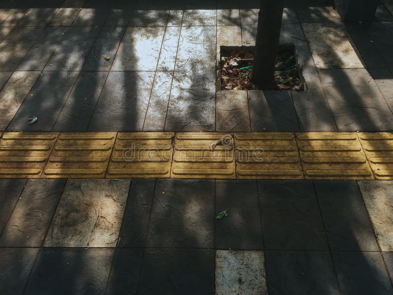 Yellow Pedestrian Path for the Disabled on a Sidewalk Stock Photo ...
