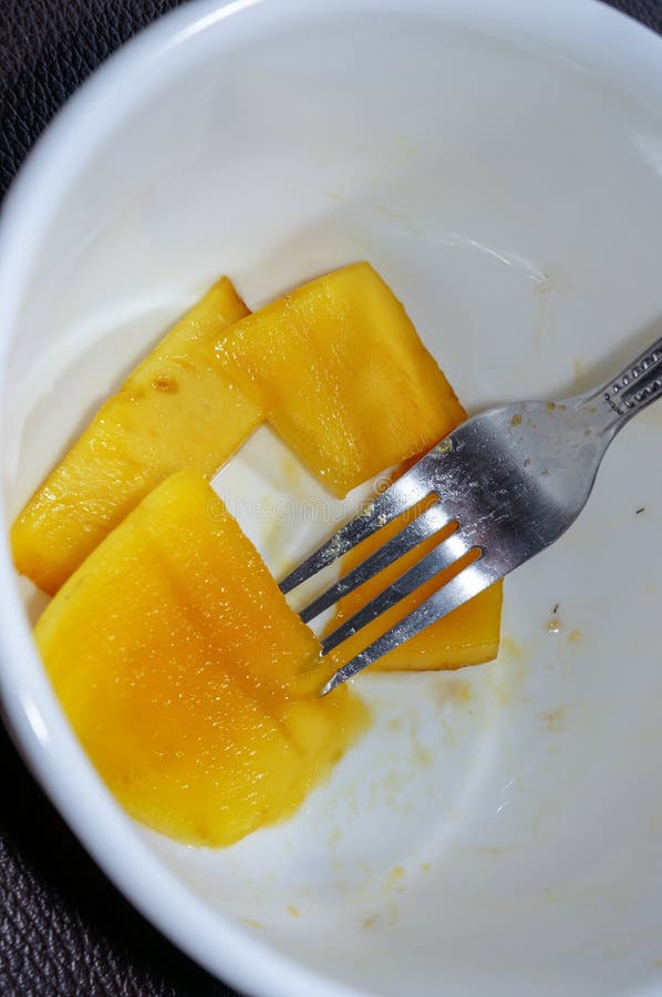 Yellow Pieces of Mango Left in the Bowl with Fork Stock Photo - Image ...