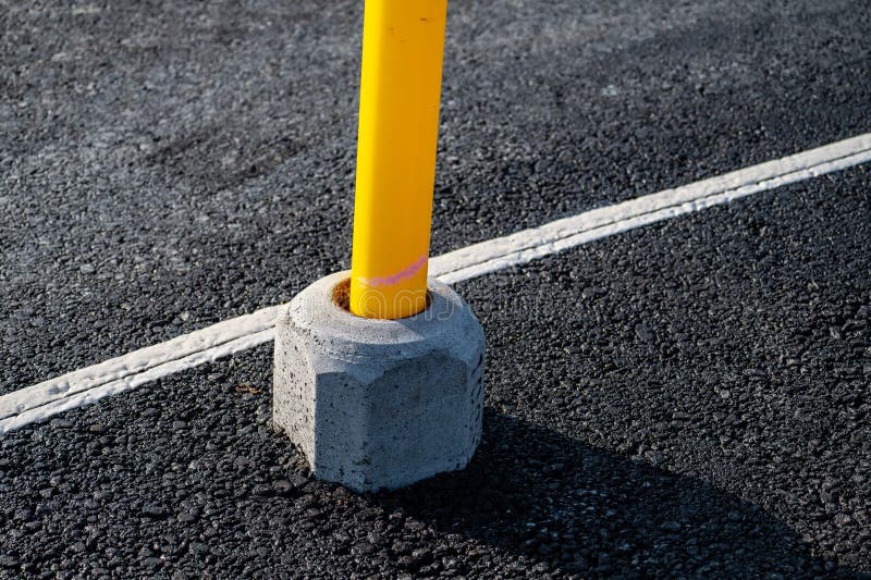 Yellow Pipe on a Light Pole Base on Asphalt.. Stock Photo - Image of ...