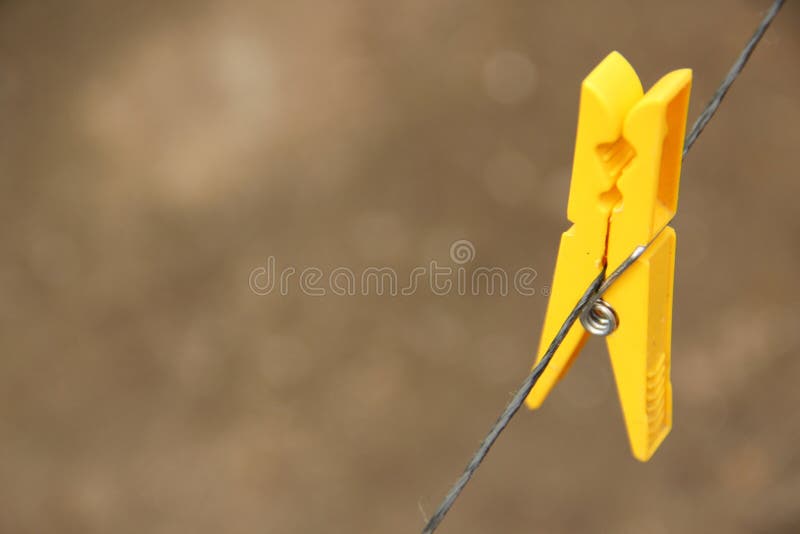 A Yellow Plastic Clothes Pin Hanging on a Wire Stock Image - Image of ...