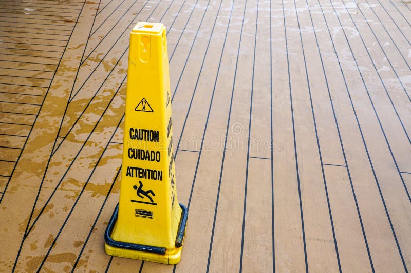 A Yellow Plastic Warning Pylon about the Slippery Wet Floor on the Deck ...