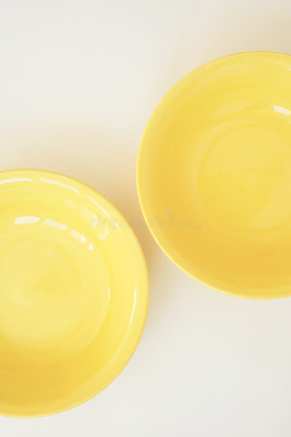 Two Yellow Plates on a White Background Stock Photo - Image of diagonal ...