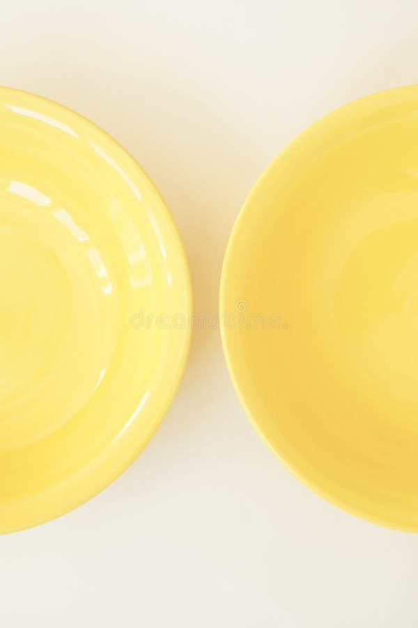 Two Yellow Plates on a White Background Stock Photo - Image of diagonal ...