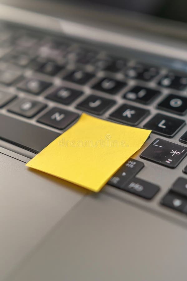 A Yellow Post-it Note Sits on Top of a Laptop Keyboard, Providing a ...
