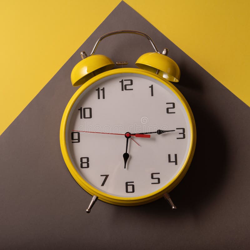 Yellow Retro Style Alarm Clock on Yellow and Brown Background Stock ...