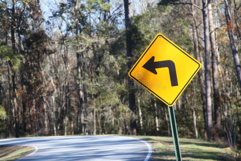 Yellow Road Sign of the Left Turn on a Road Stock Photo - Image of sign ...