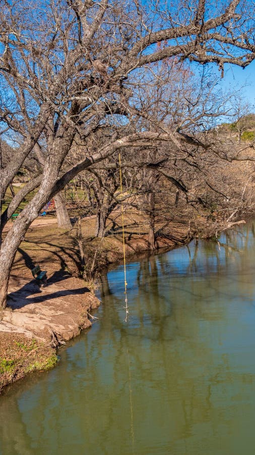 Yellow Rope Swing on a Tree Growing Over the Water on a River Stock ...
