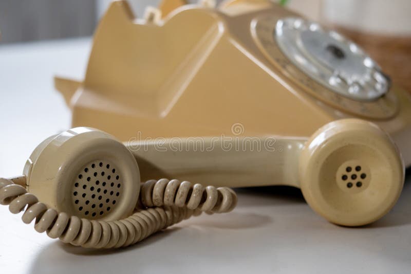 Yellow Rotary Telephone with a White Cord Sits on a Table. it is Old ...
