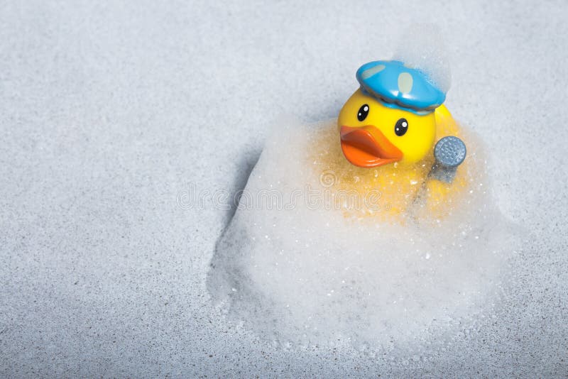 A Yellow Rubber Duck for a Bath in a Bath Cap and with a Shower Head in ...