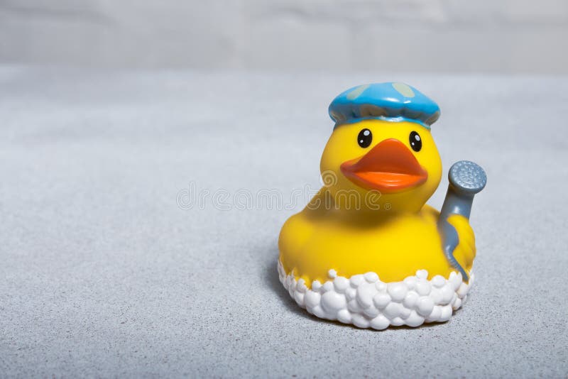 Yellow Rubber Duck for a Bath in a Bath Cap and with a Shower Head in ...