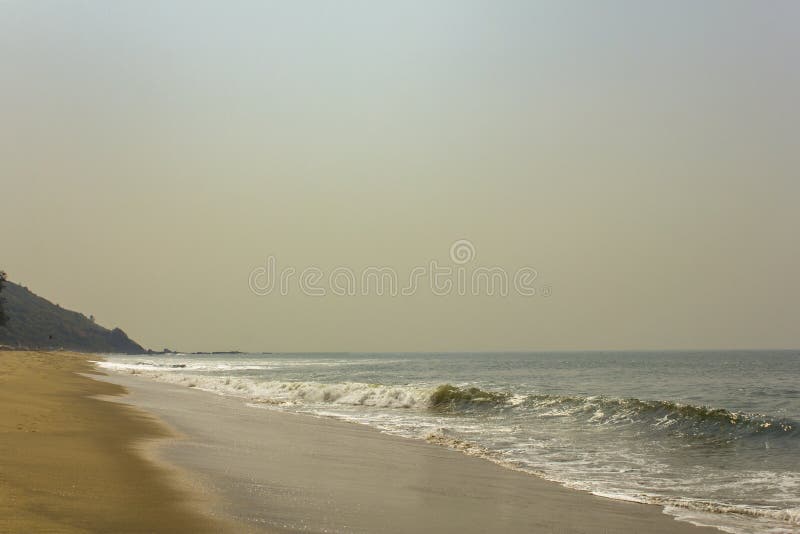 Yellow Sandy Beach on the Background of the Ocean with Waves Under a ...