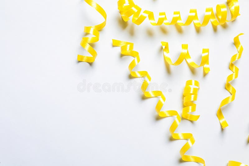 Yellow Serpentine Streamers on White Background, Top View Stock Photo ...