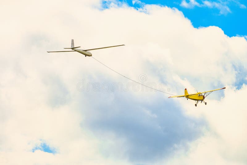 Yellow Small Light-engine Sport Plane Flying in the Cloudy Sky Pulls on ...