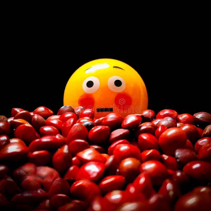 Yellow smiley on red seeds stock image. Image of organ - 190600031