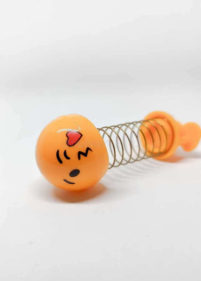 Yellow Spring Toy with Emoticon Face Shape on White Background Stock ...
