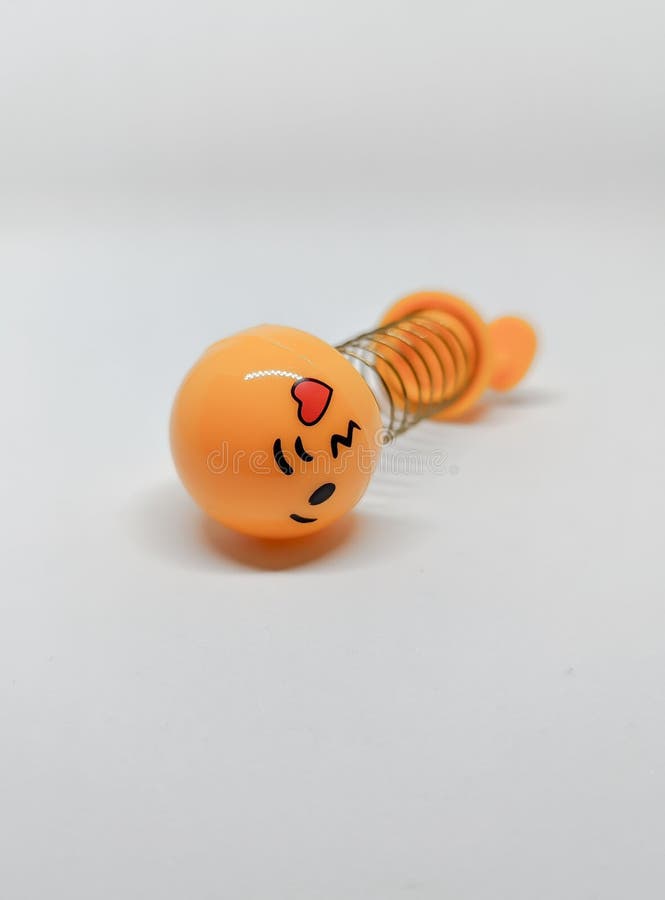 Yellow Spring Toy with Emoticon Face Shape on White Background Stock ...