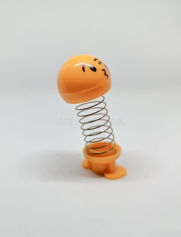 Yellow Spring Toy with Emoticon Face Shape on White Background Stock ...