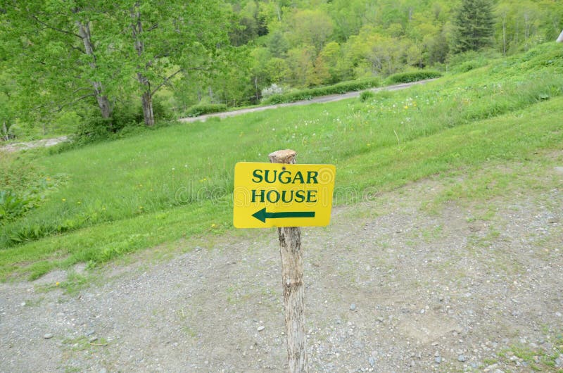 Yellow Sugar House Sign with Arrow and Green Grass Stock Image - Image ...