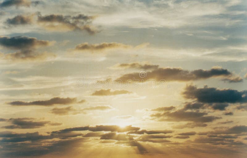 A Yellow Sunny Sky with Clouds and Sun Rays Stock Photo - Image of ...