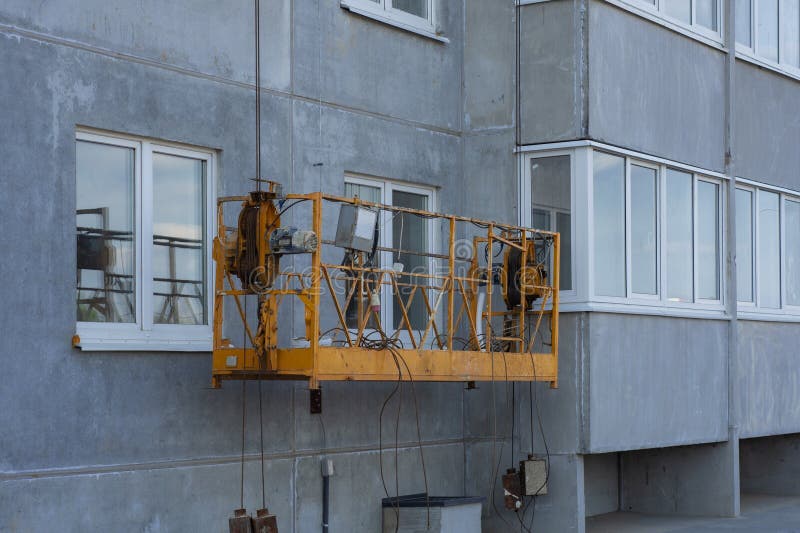Yellow Suspended Platform Hangs on a Building Facade, Equipped for ...
