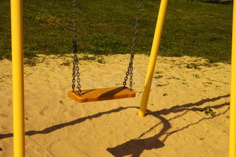 A Yellow Swing on a Playground Stock Photo - Image of swinging, seat ...
