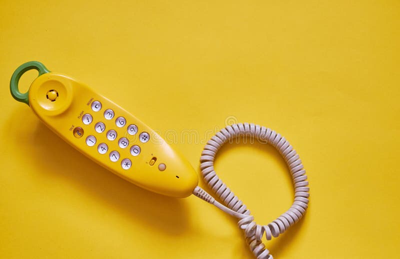 A Yellow Telephone Receiver with a Wire Lies on a Yellow Background ...
