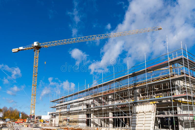 Yellow Tower Crane Above a Building Under Construction in Scaffolding ...