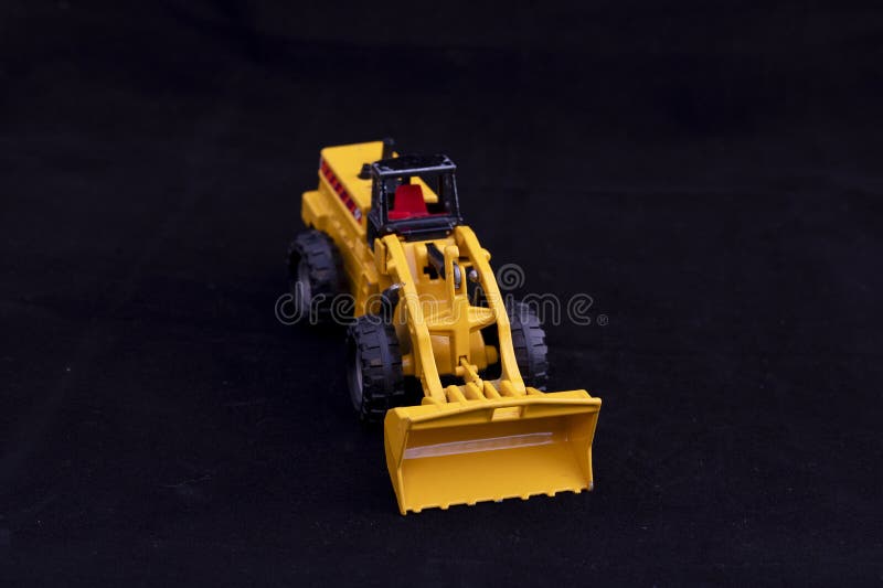 Yellow Toy Front Loader Machine on Black Background Stock Image - Image ...
