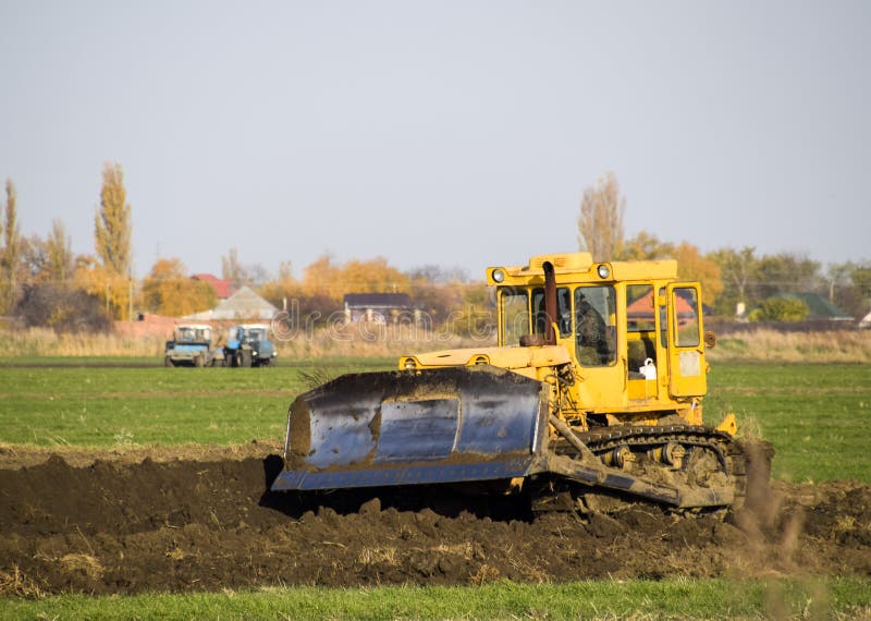 The Yellow Tractor with Attached Grederom Makes Ground Leveling Stock ...