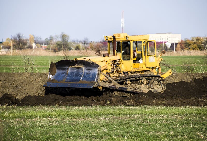 The Yellow Tractor with Attached Grederom Makes Ground Leveling. Stock ...