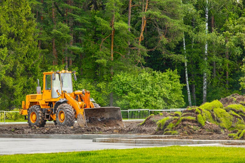Yellow Tractor with Bucket Doing Landscaping Work. Stock Photo - Image ...