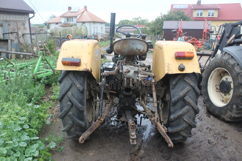 Yellow Tractor without a Cab in the Courtyard of a Dairy Farm. Stock ...
