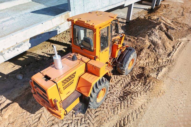 A Yellow Tractor is Parked in Rough Dirt, Ready for Construction Work ...