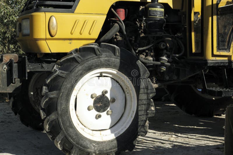 A Yellow Tractor Stands in a Field on a Farm Stock Photo - Image of ...