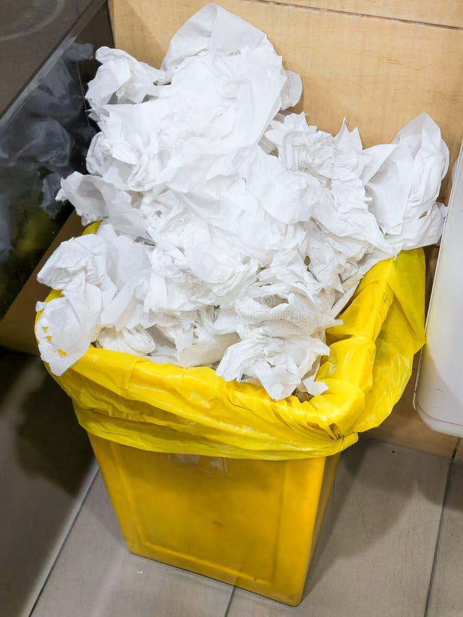 Yellow Trash Can in the Bathroom with Bits of Toilet Paper Overflowing ...
