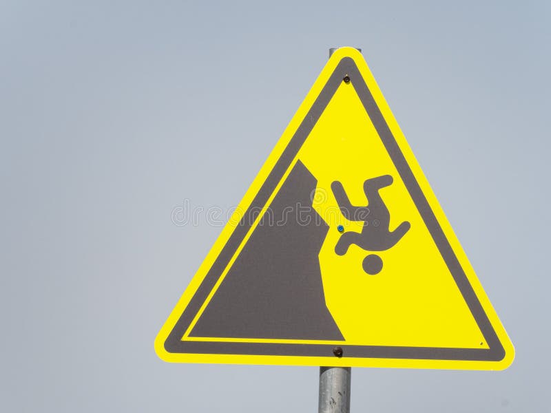 Yellow Triangular Sign with a Man Falling from a Cliff on a Gray ...