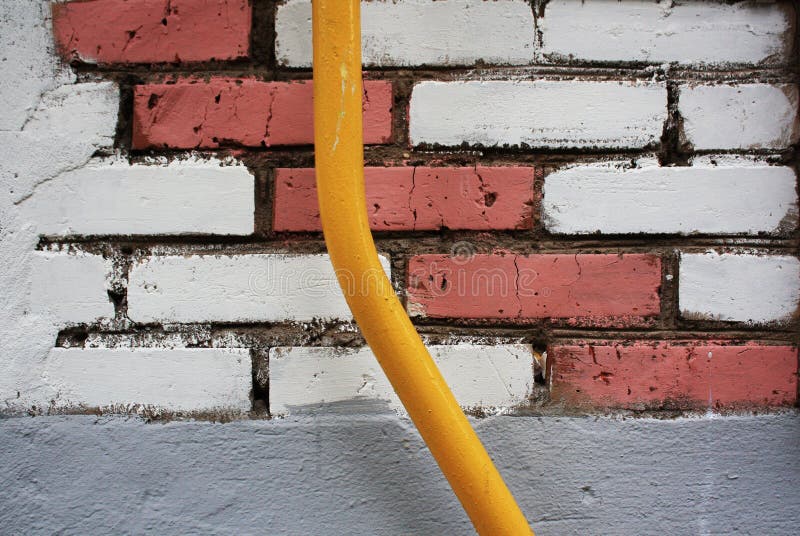 Yellow tube on brick wall stock photo. Image of seams - 61135188