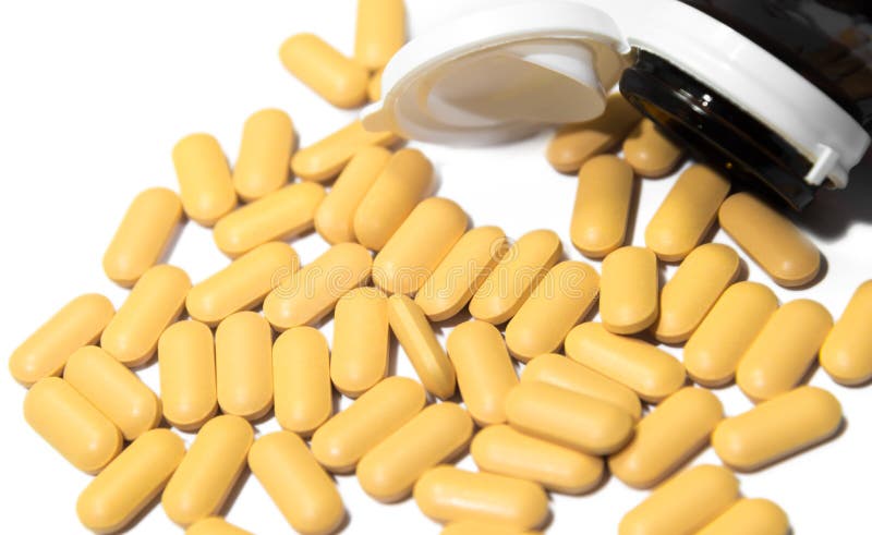 Yellow Vitamin Tablet Poured from Brown Bottle Isolated Stock Photo ...