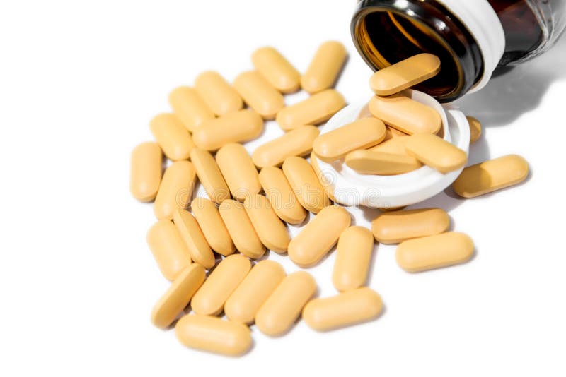 Yellow Vitamin Tablet Poured from Brown Bottle Isolated Stock Photo ...