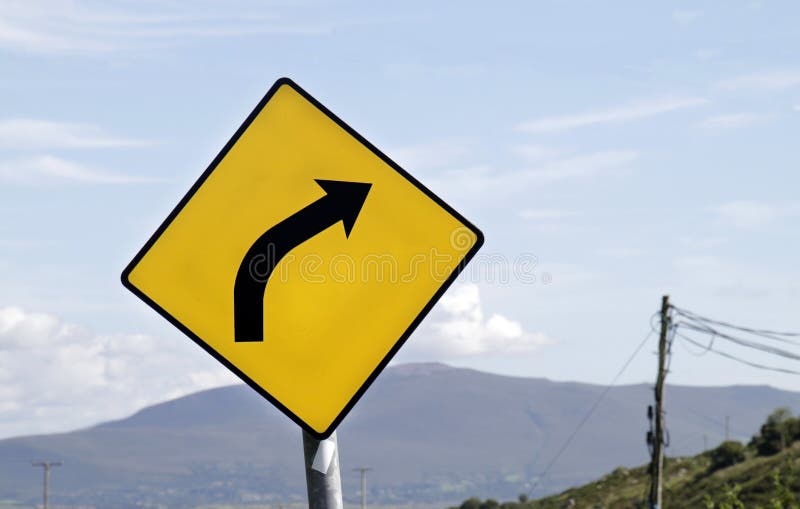Yellow Curve Road Sign on the Road Surrounded by Rocky Mountains in the ...