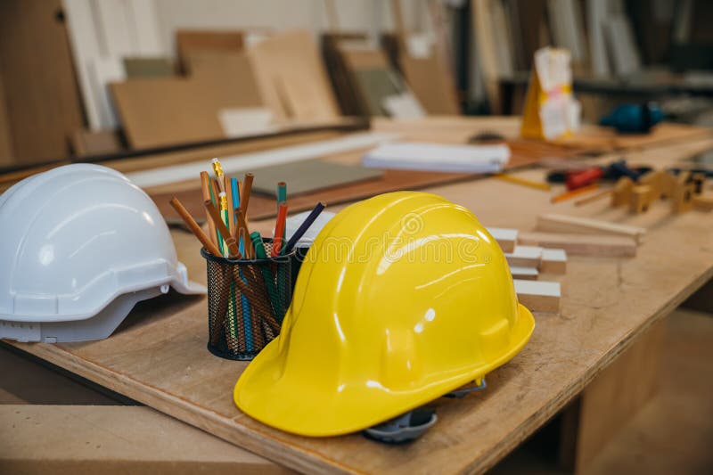 Yellow and White Hard Hats on a Wooden Table with Pencils. Ideal for ...